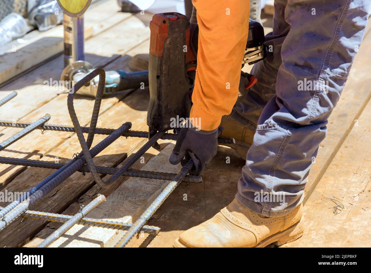 Construction worker use rebar tying tools to secure steel bars with ...
