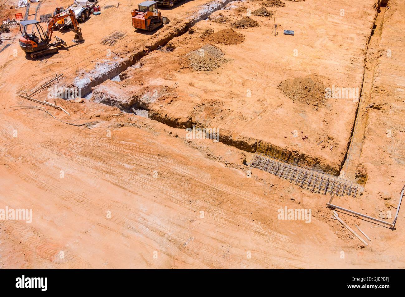 An aerial view of a new home building site with a trench dug under a ...