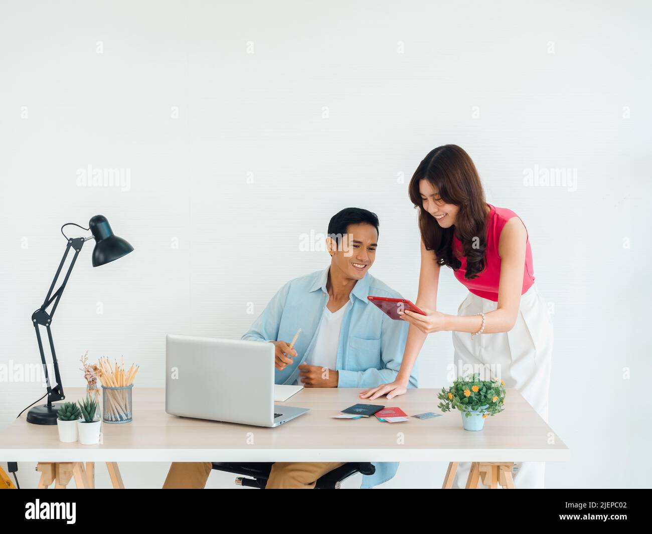 Happy Asian couple, young woman and man using tablet and laptop ...