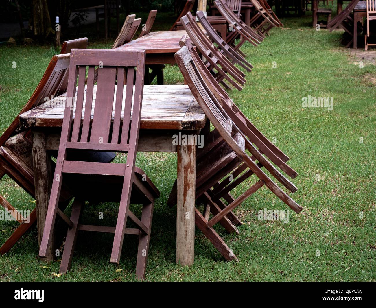 Empty old abandoned wooden dining table set on the green yard garden ...