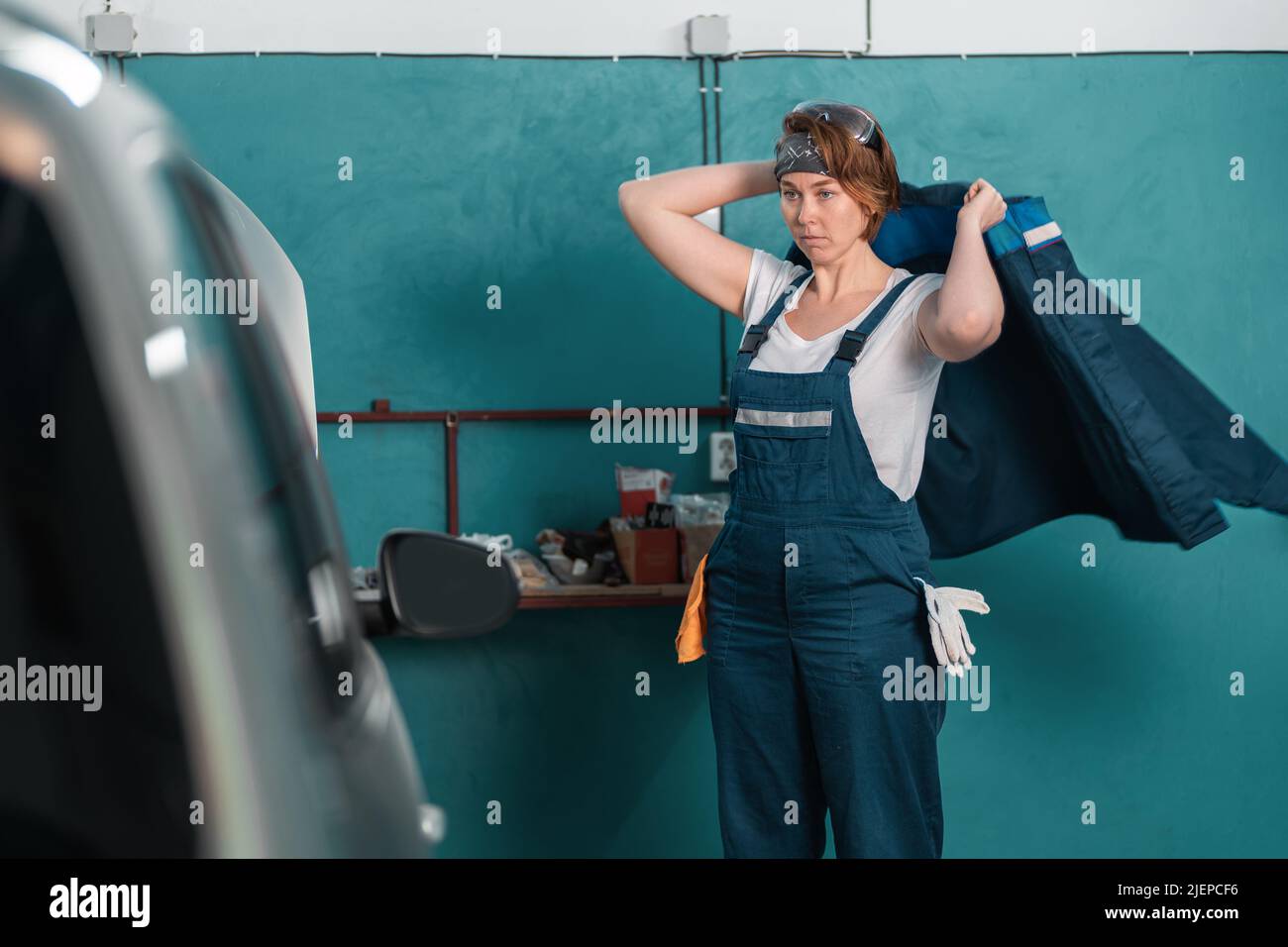 A young female mechanic wear on a work jacket. The concept of women's ...