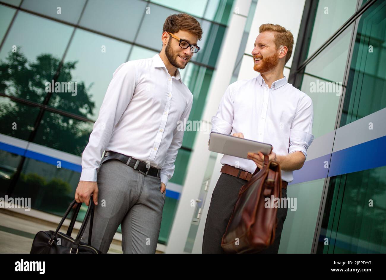 Two successful business men walking outdoors. Business, friendship ...