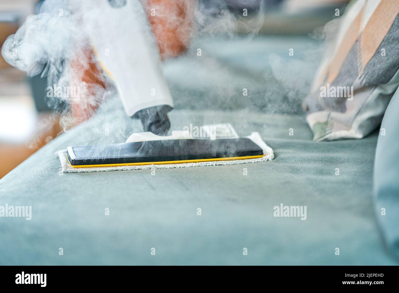 Picture of steam cleanier over green couch Stock Photo - Alamy