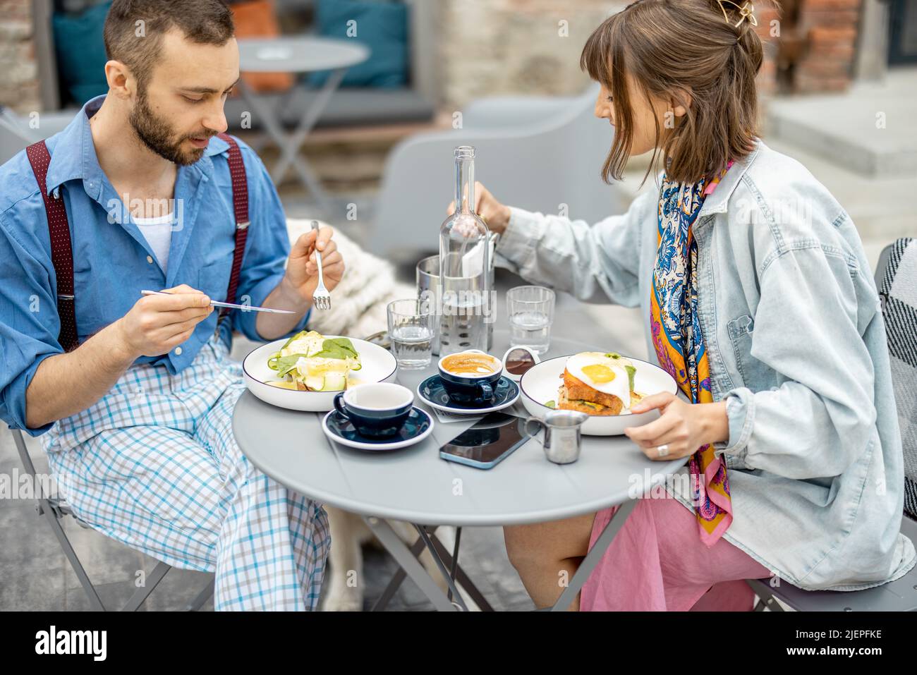Stylish man and woman have delicious breakfast at cafe outdoors Stock ...
