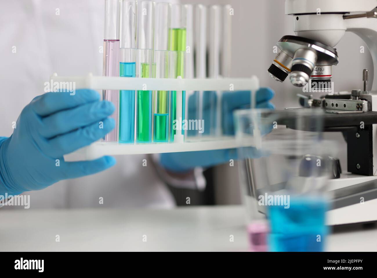 Scientist is holding test tubes with blue green liquids in laboratory ...