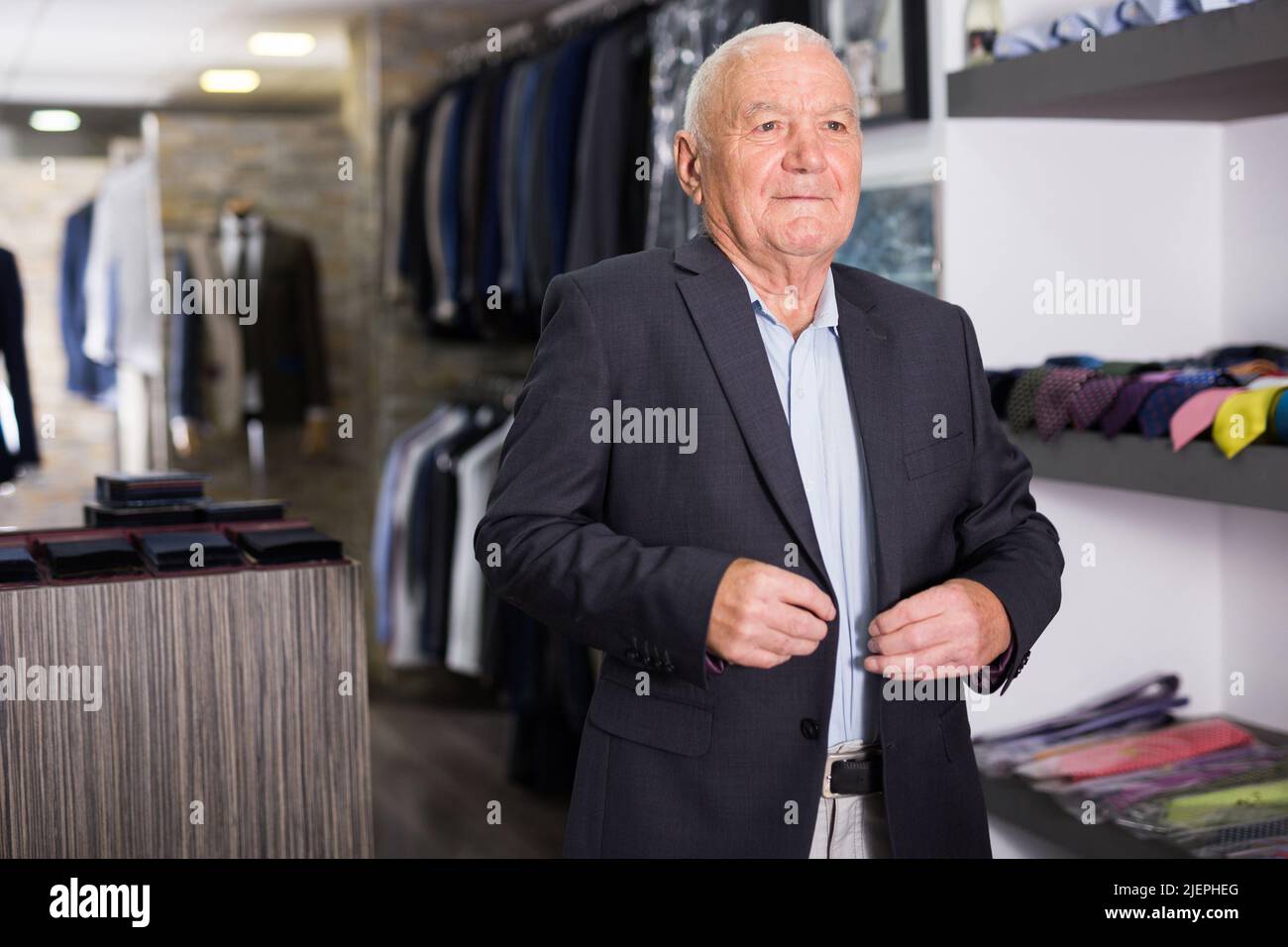 Mature male shopper shows off his jacket at men's store Stock Photo - Alamy