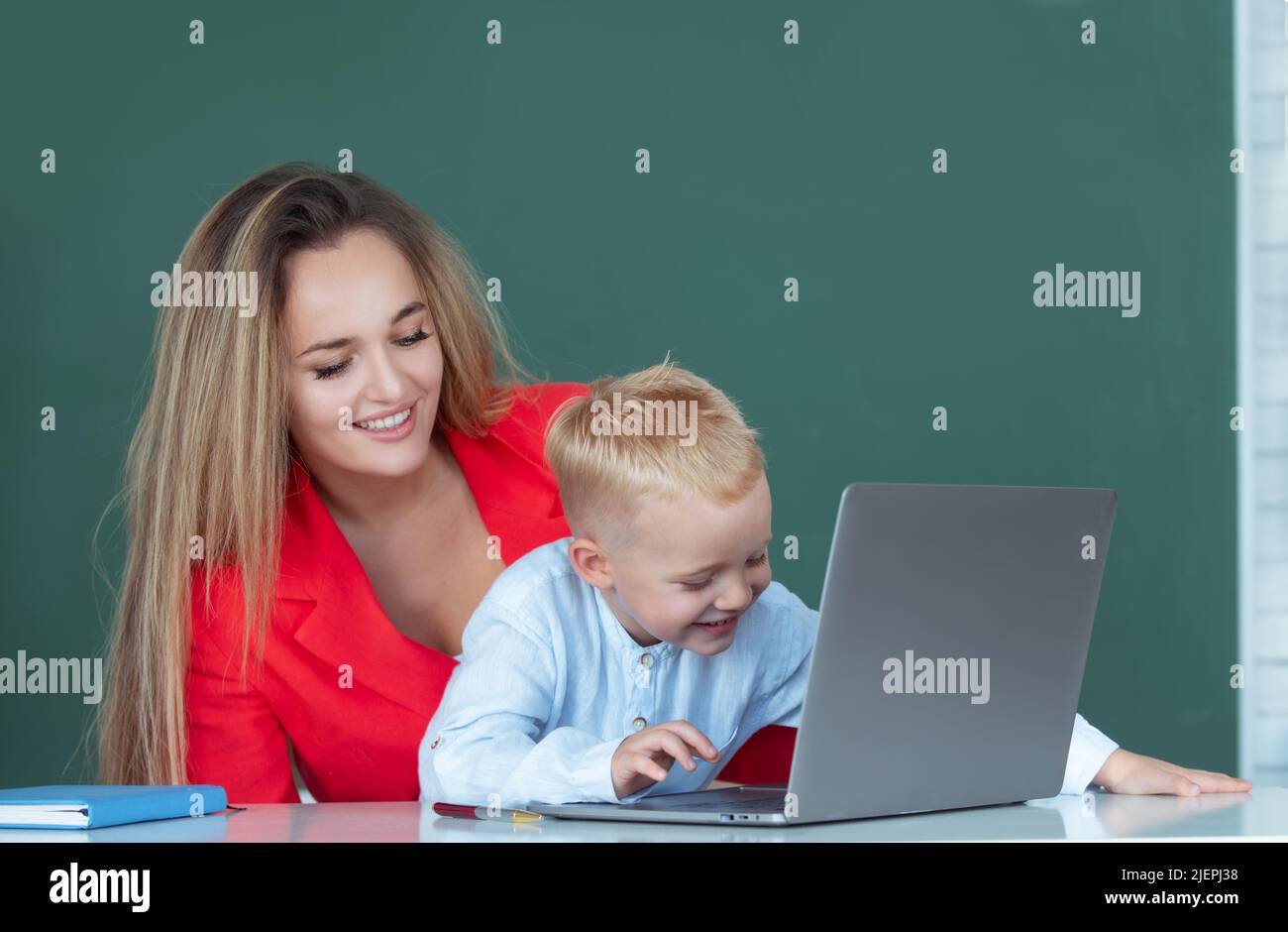 Portrait of schoolkids and teacher talking at school lesson. Mother and ...