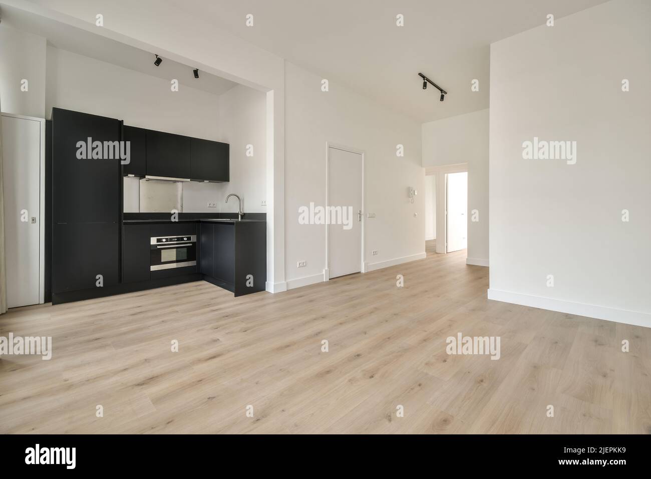 An empty bright room with a window and a minimalistic stylish kitchen ...