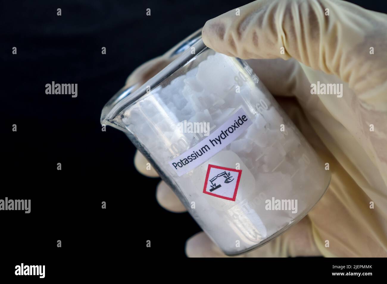Potassium hydroxide flake on black background, chemistry in the ...