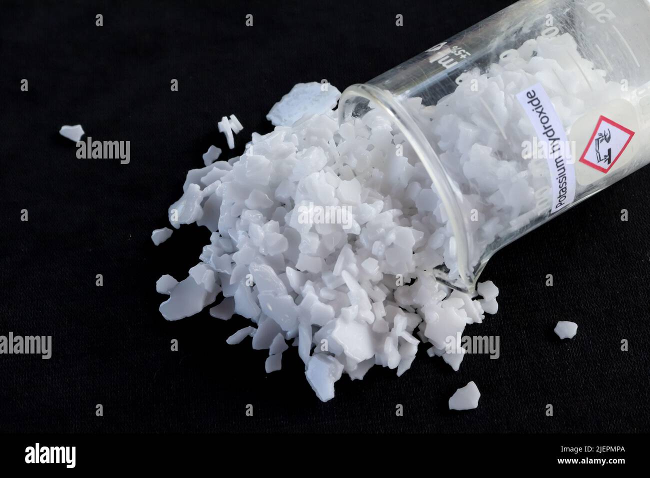 Potassium hydroxide flake on black background, chemistry in the ...