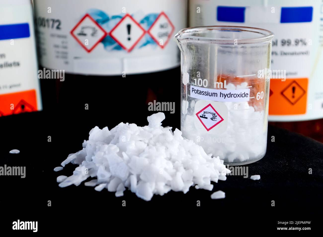 Potassium hydroxide flake on black background, chemistry in the ...