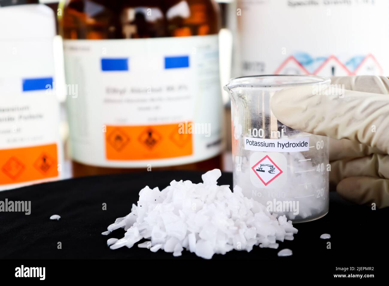 Potassium hydroxide flake on black background, chemistry in the ...