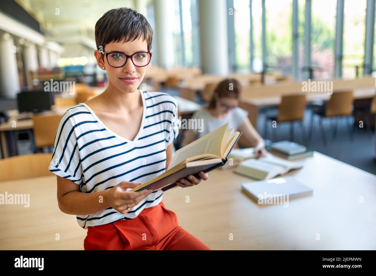 Students studying in library. Young success people are spending time ...