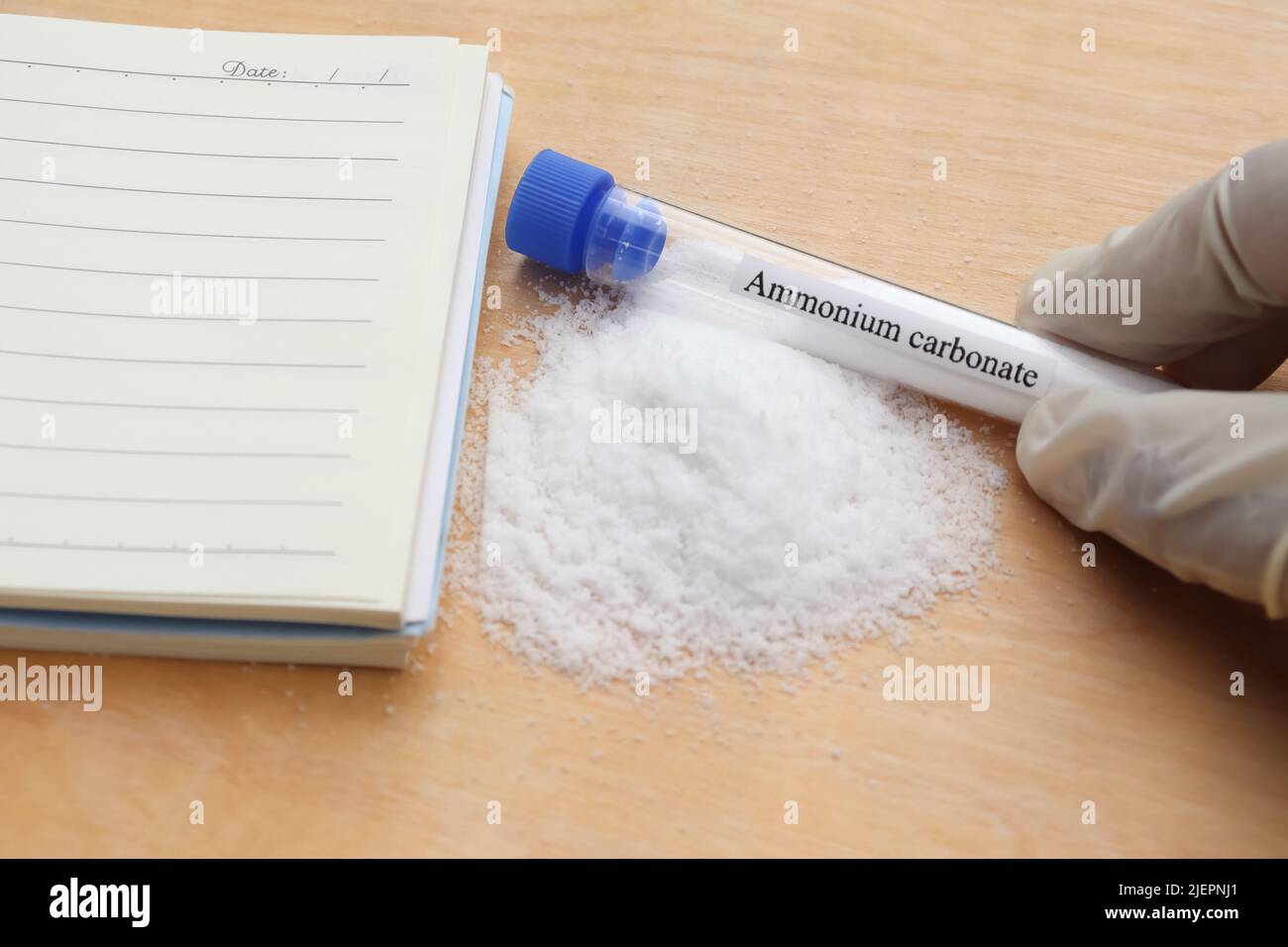 ammonium carbonate in test tube and wood background Stock Photo - Alamy