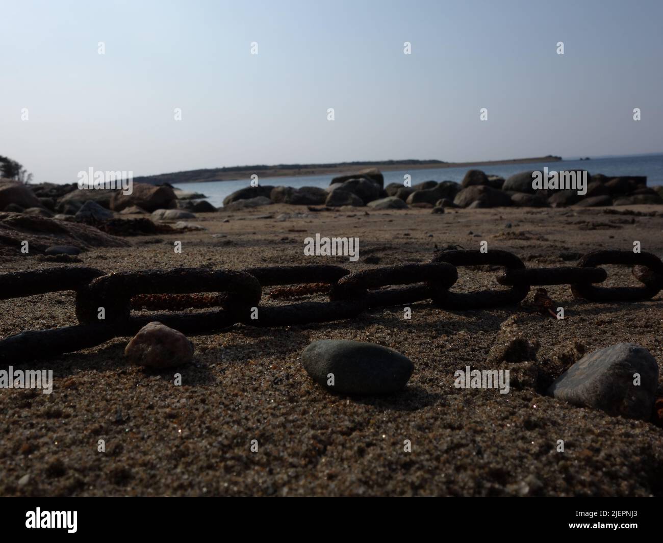 Metal chain lying in the sand on the beach Stock Photo - Alamy