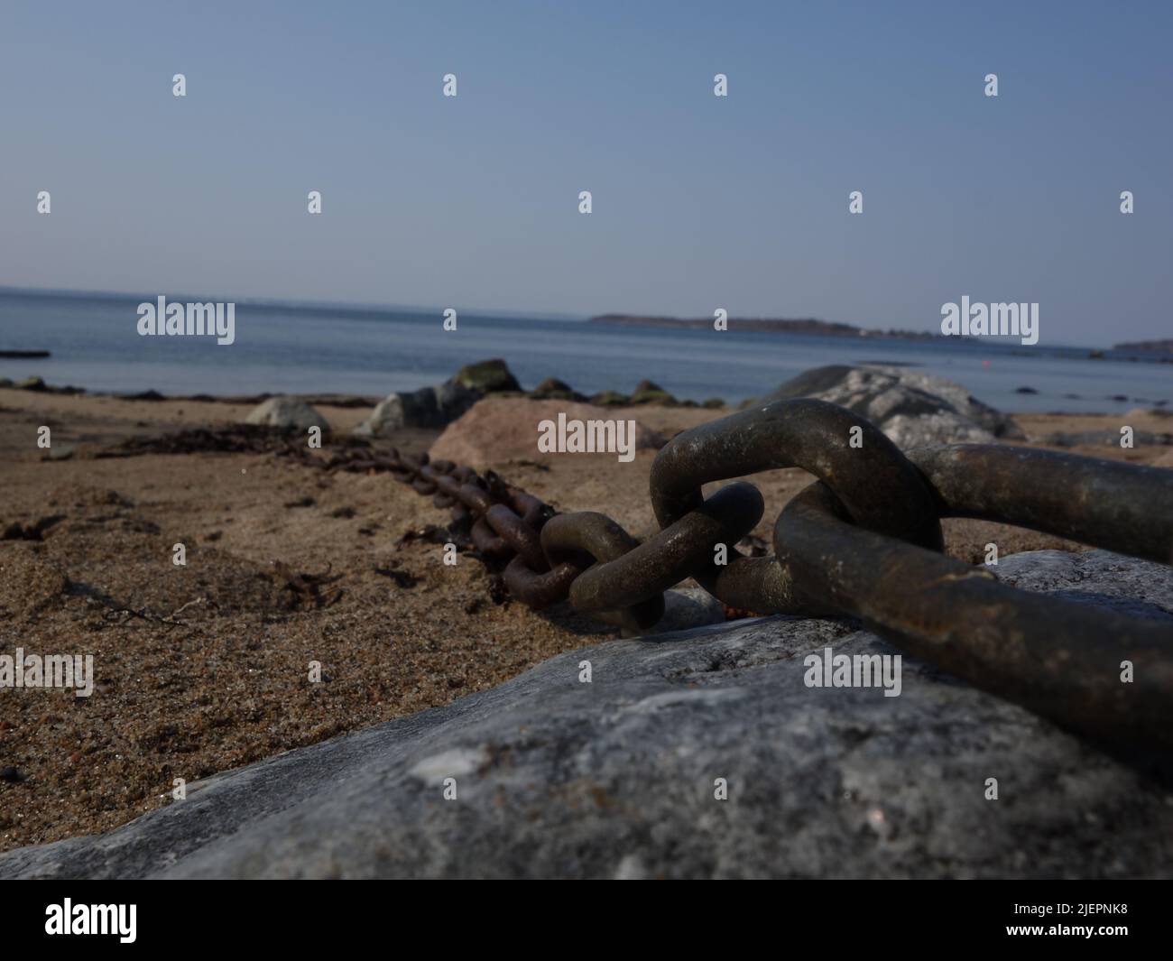 Metal chain lying in the sand on the beach Stock Photo - Alamy