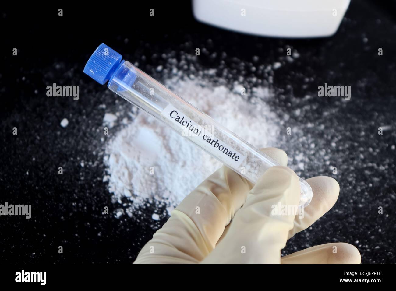 Calcium carbonate in test tube and black background Stock Photo - Alamy