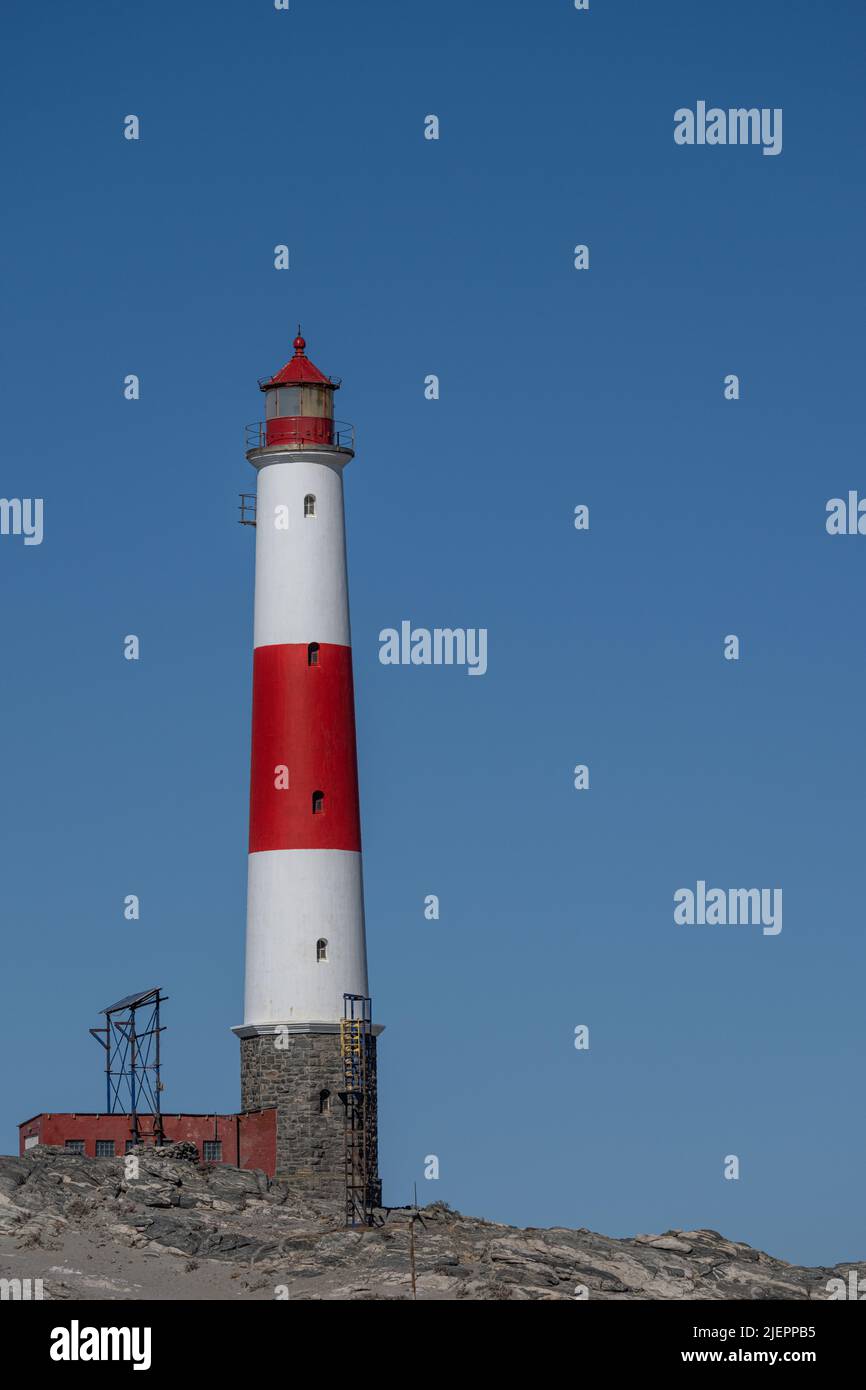 A white and red lighthouse in front of a blue sky at Diaz Point near ...