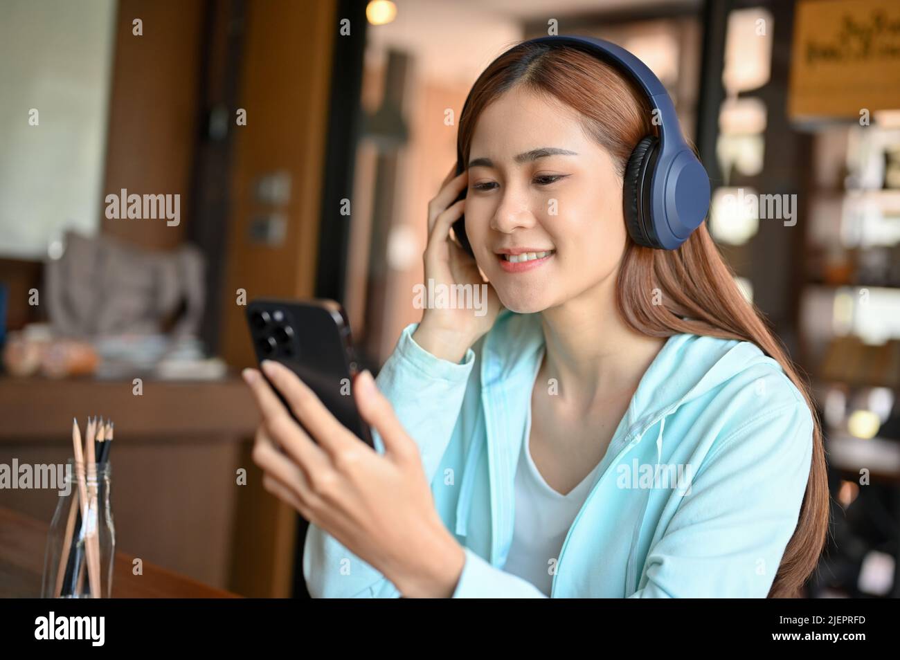 Pretty and charming young Asian female college student using smartphone ...