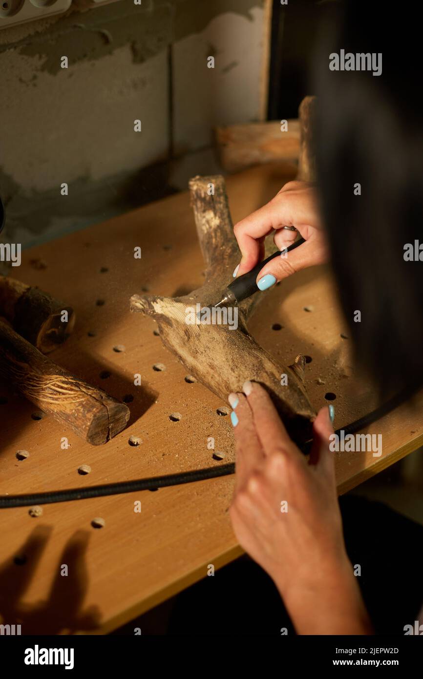 Female using power wood working tools graver, carving while crafting ...
