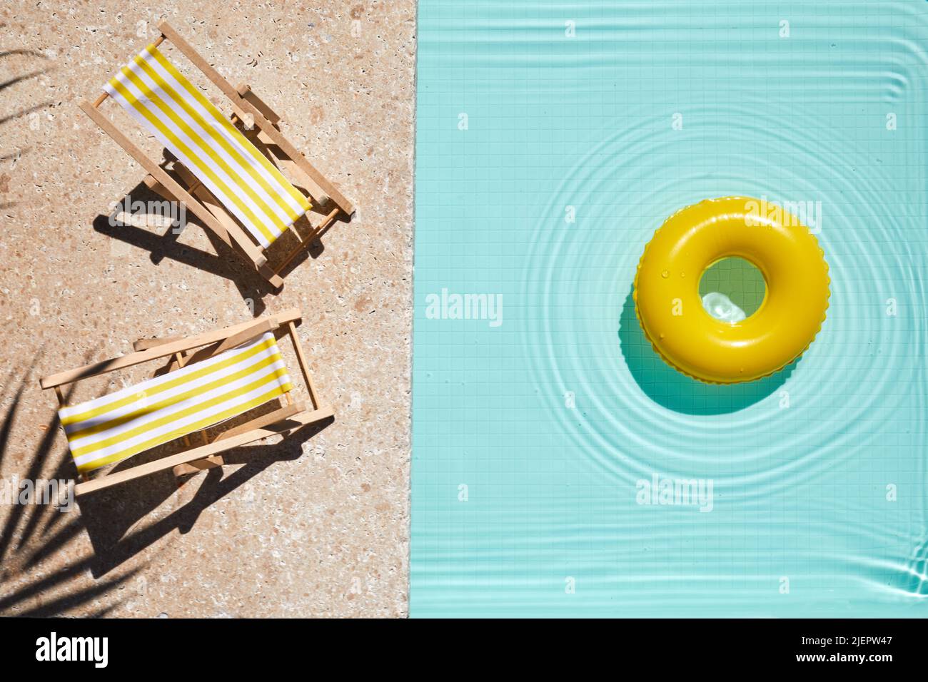 Top view swimming pool with yellow chaise lounge and swimming ring ...