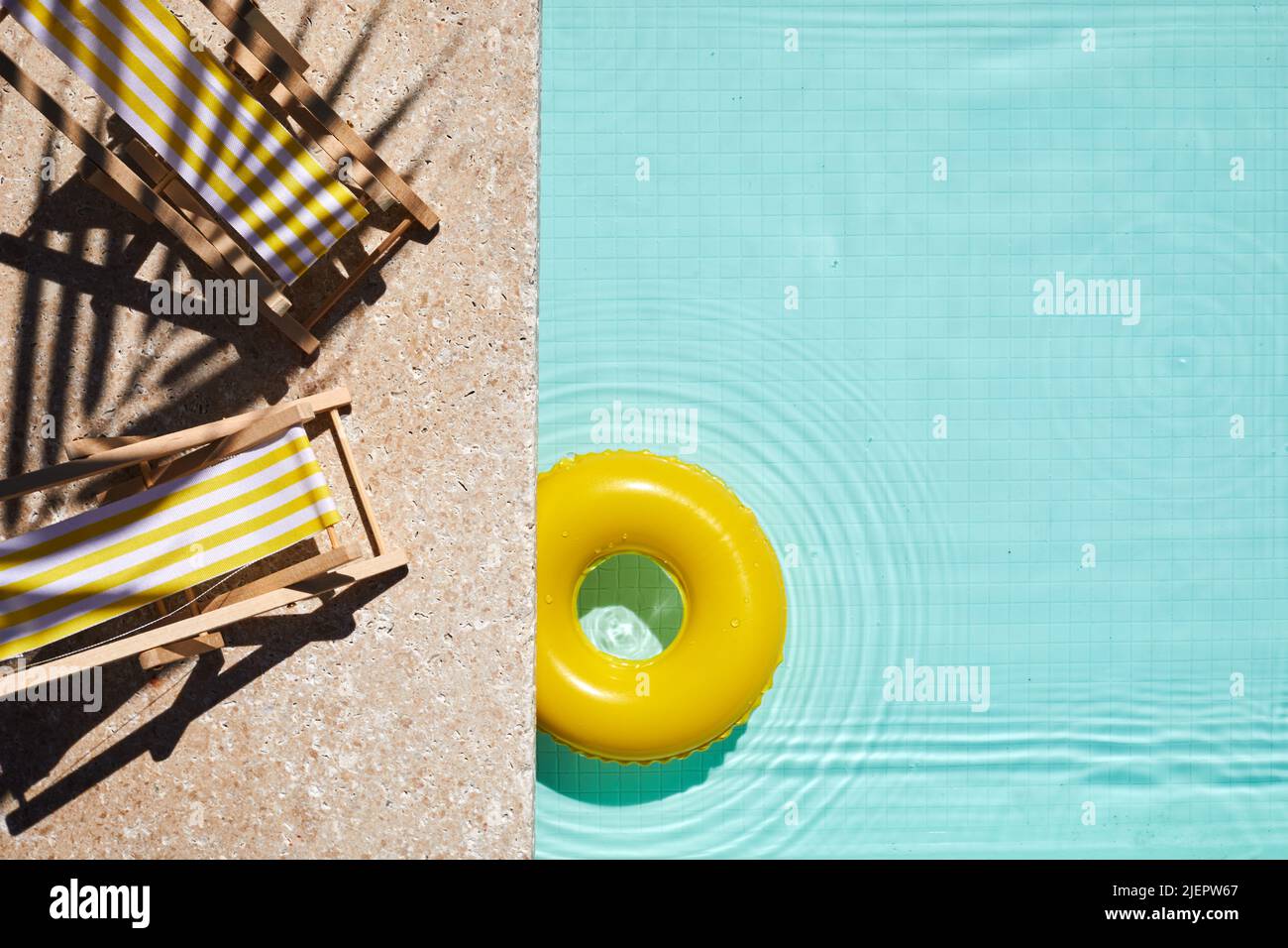 Top view swimming pool with yellow chaise lounge and swimming ring ...