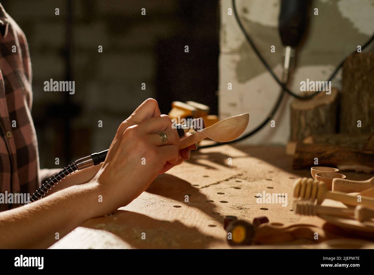 Female using power working tools graver for wooden utensils spoon ...