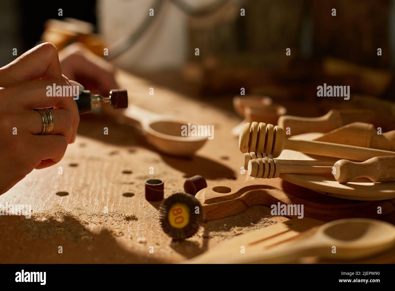 Female using power working tools graver for wooden utensils spoon ...