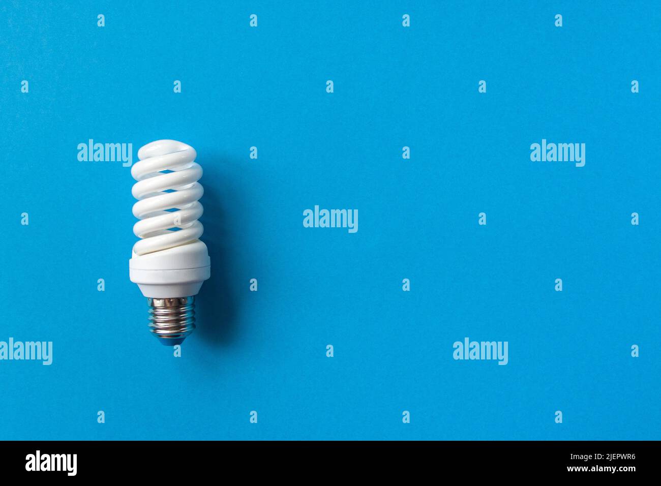 Energy saving light bulb on a blue background Stock Photo - Alamy