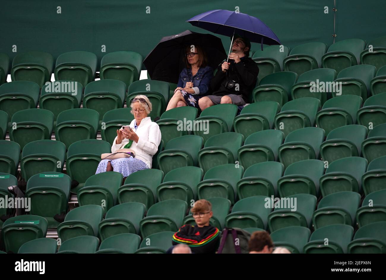 Spectators with umbrellas on day two of the 2022 Wimbledon ...