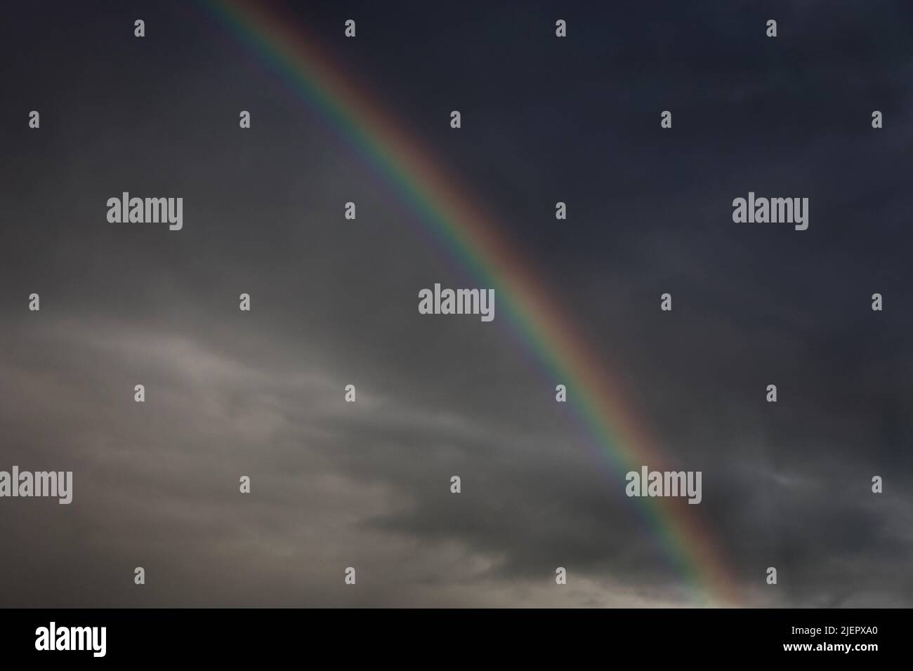 rainbow after a summer thunderstorm and rain in a dark sky Stock Photo - Alamy