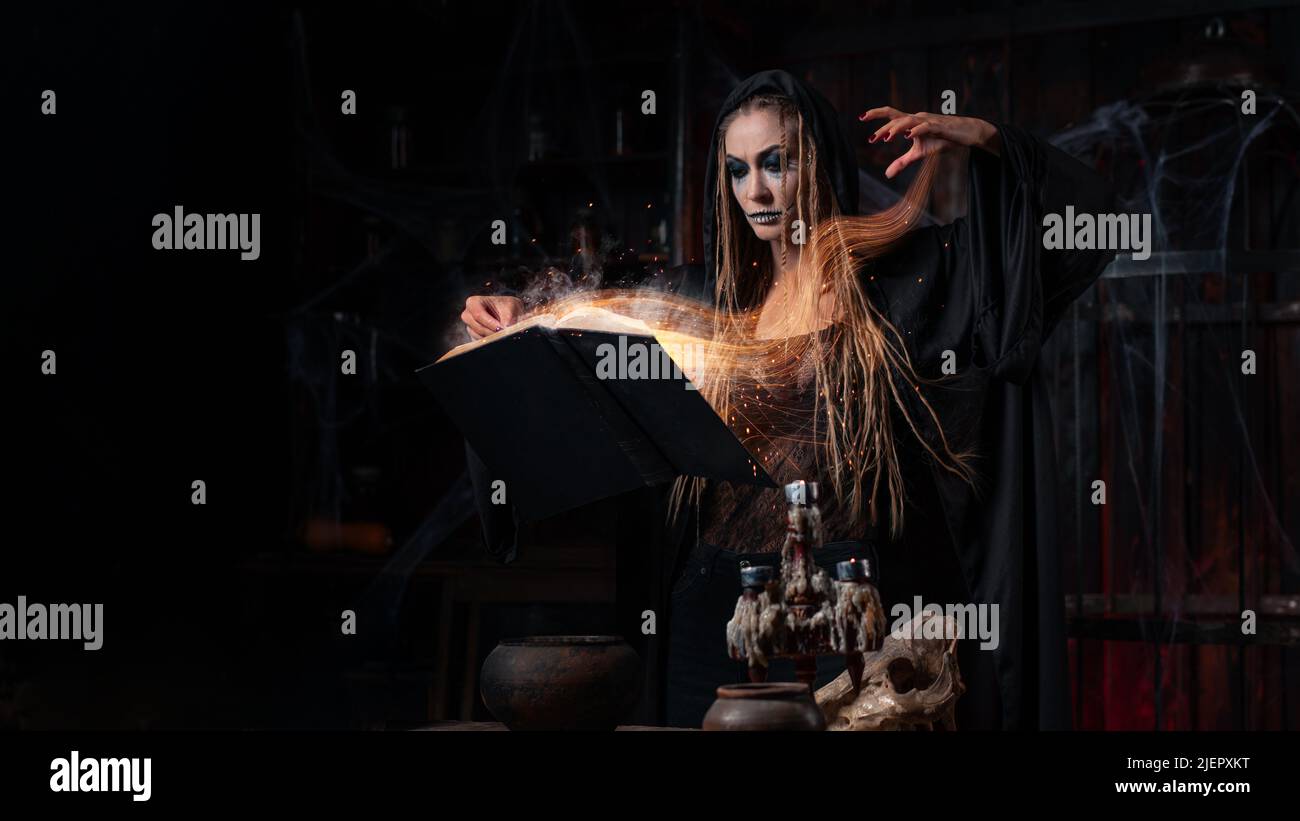Halloween concept. Witch dressed black hood with dreadlocks standing ...