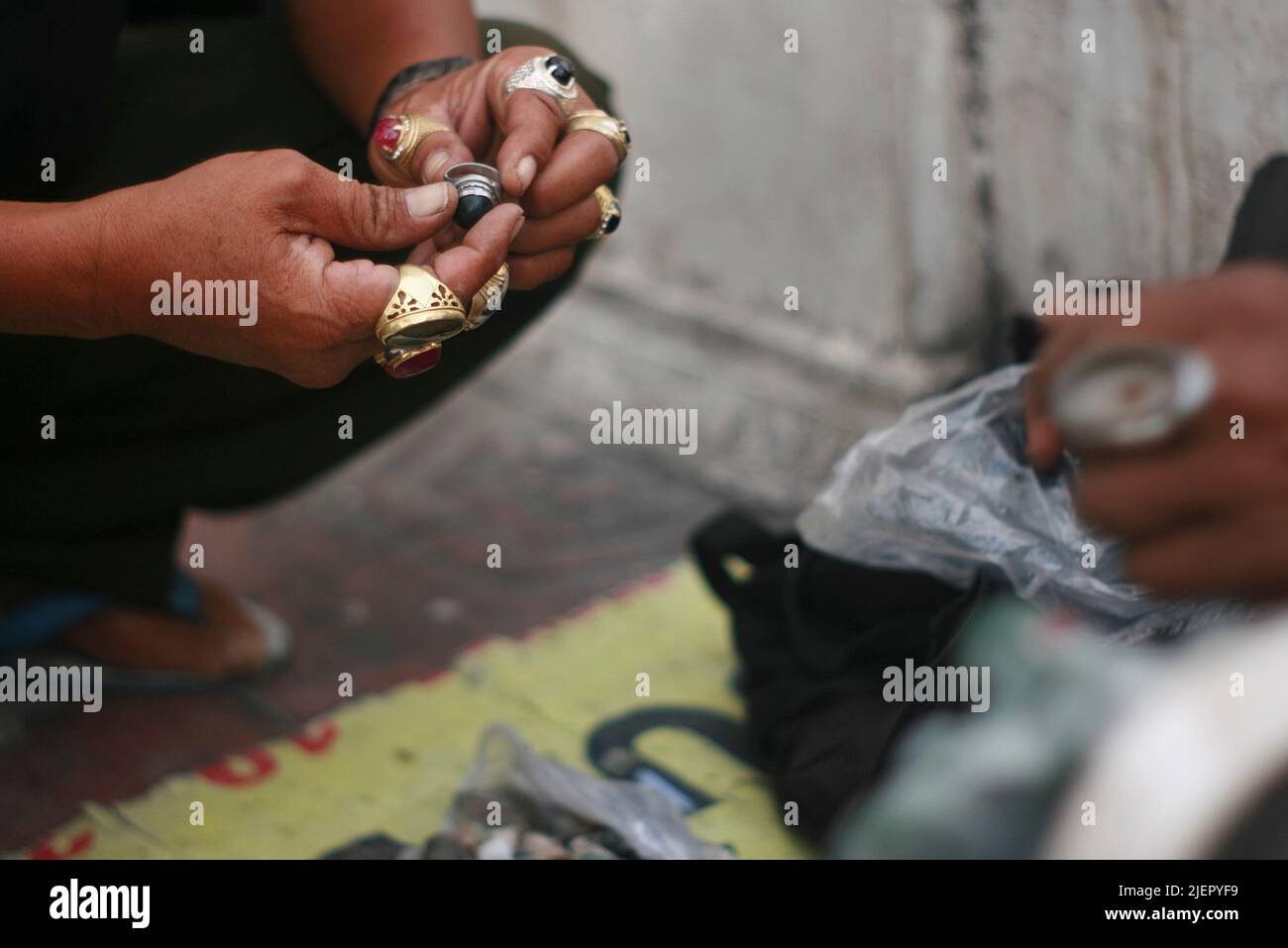 Close up of customer hand picking agate ring in the Yogyakata street ...