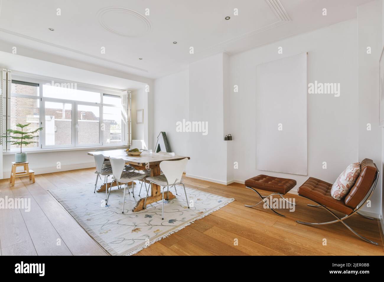 Comfortable couch located near carpet and table against window in ...