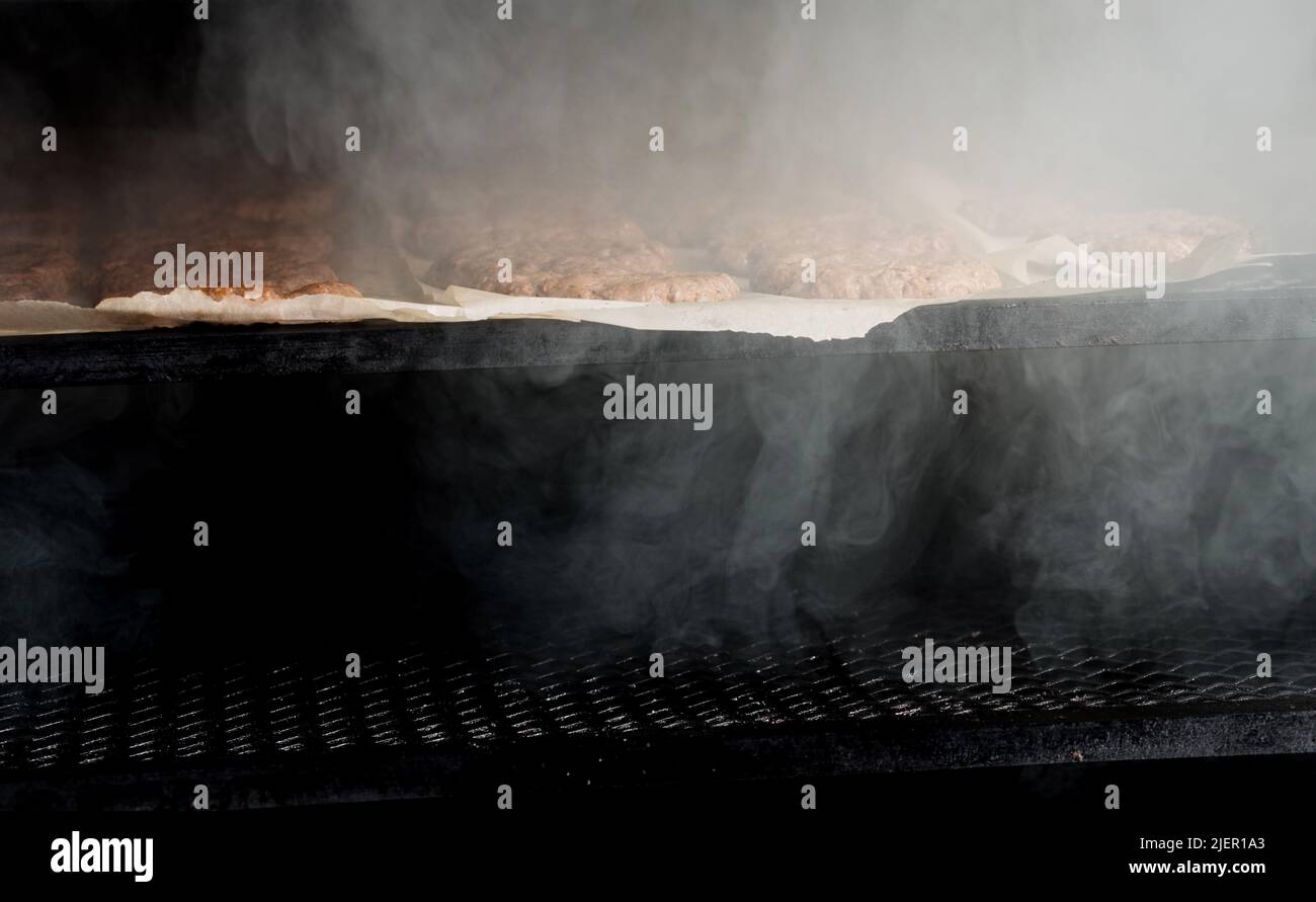 burger patties are smoking. unhealthy food. fast food Stock Photo - Alamy