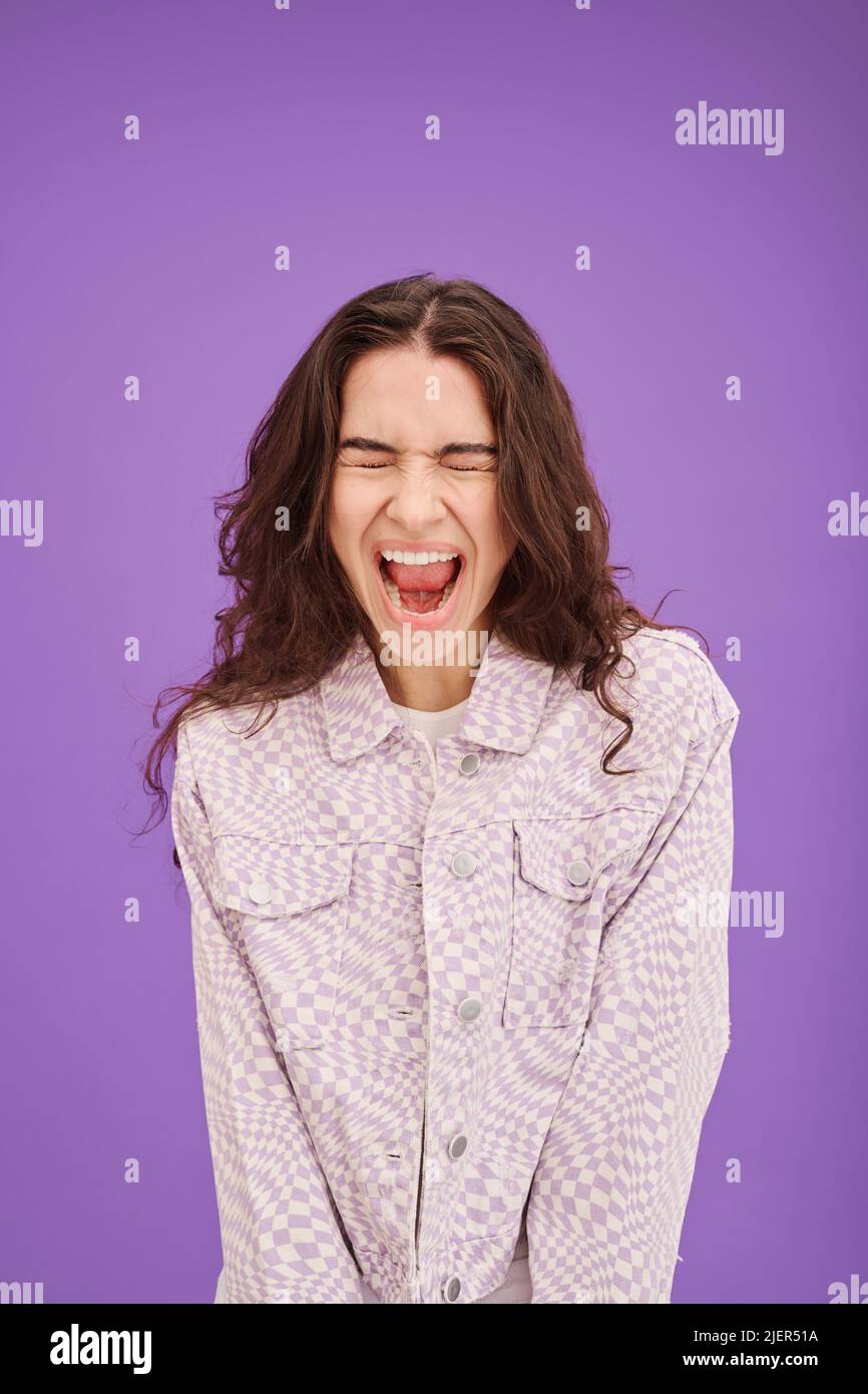 Portrait of young woman expressing her emotion by screaming isolated on ...
