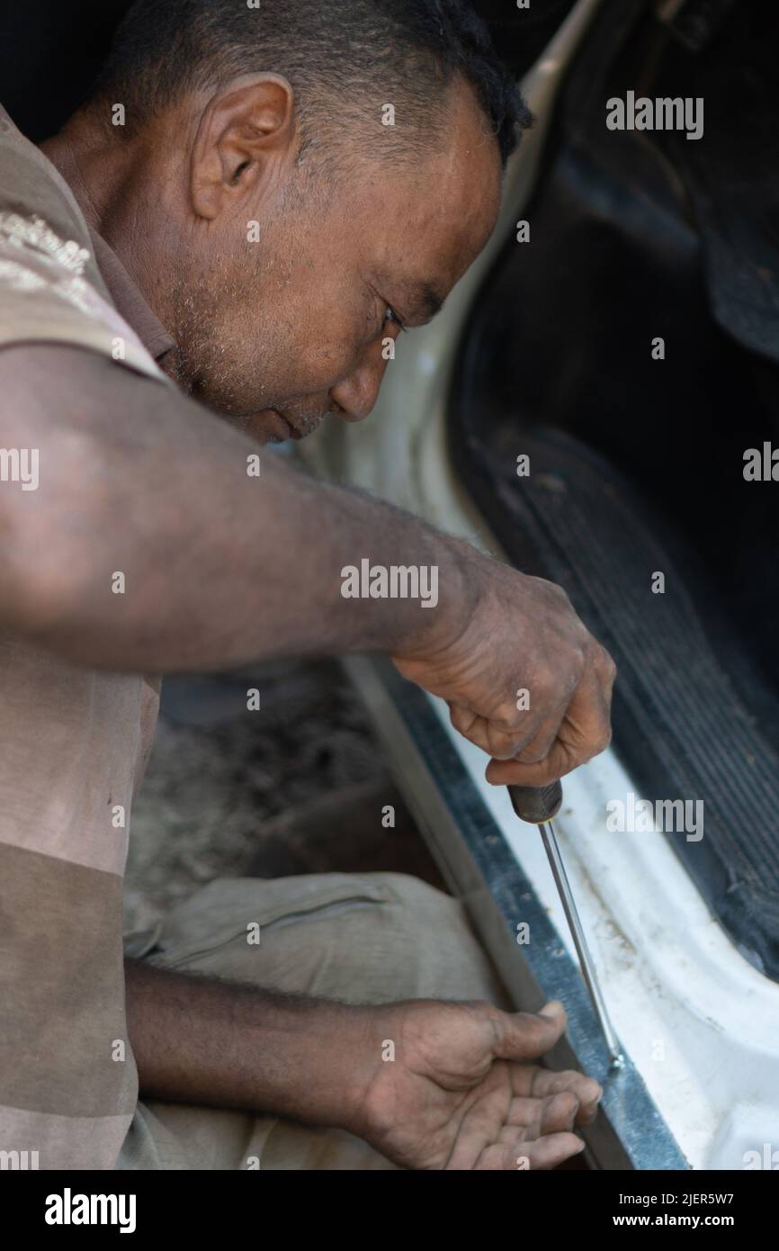 Mechanic uses force to unlock bolt Stock Photo - Alamy
