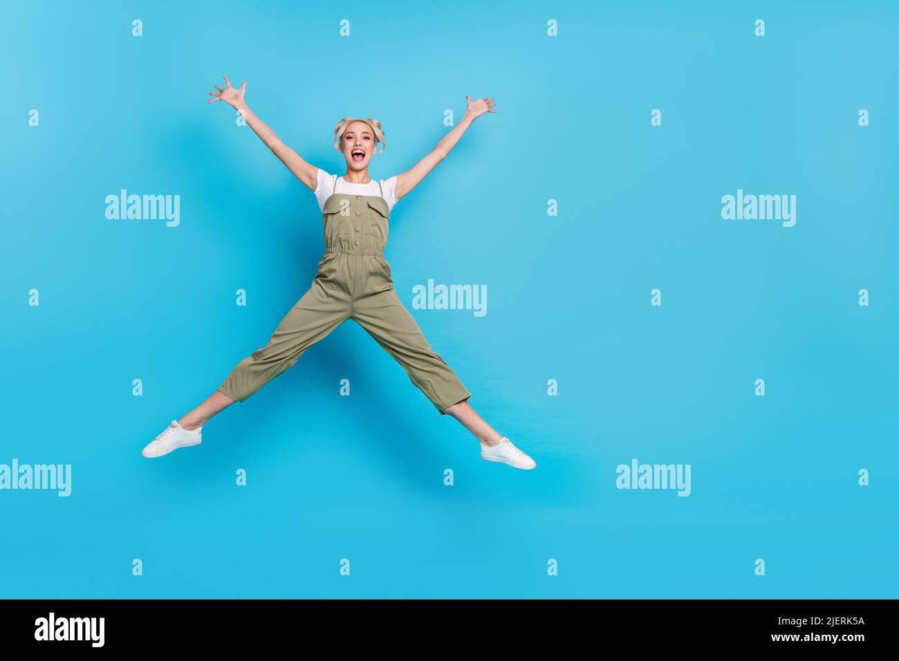 Full body photo of hooray young lady jump wear t-shirt overall sneakers ...