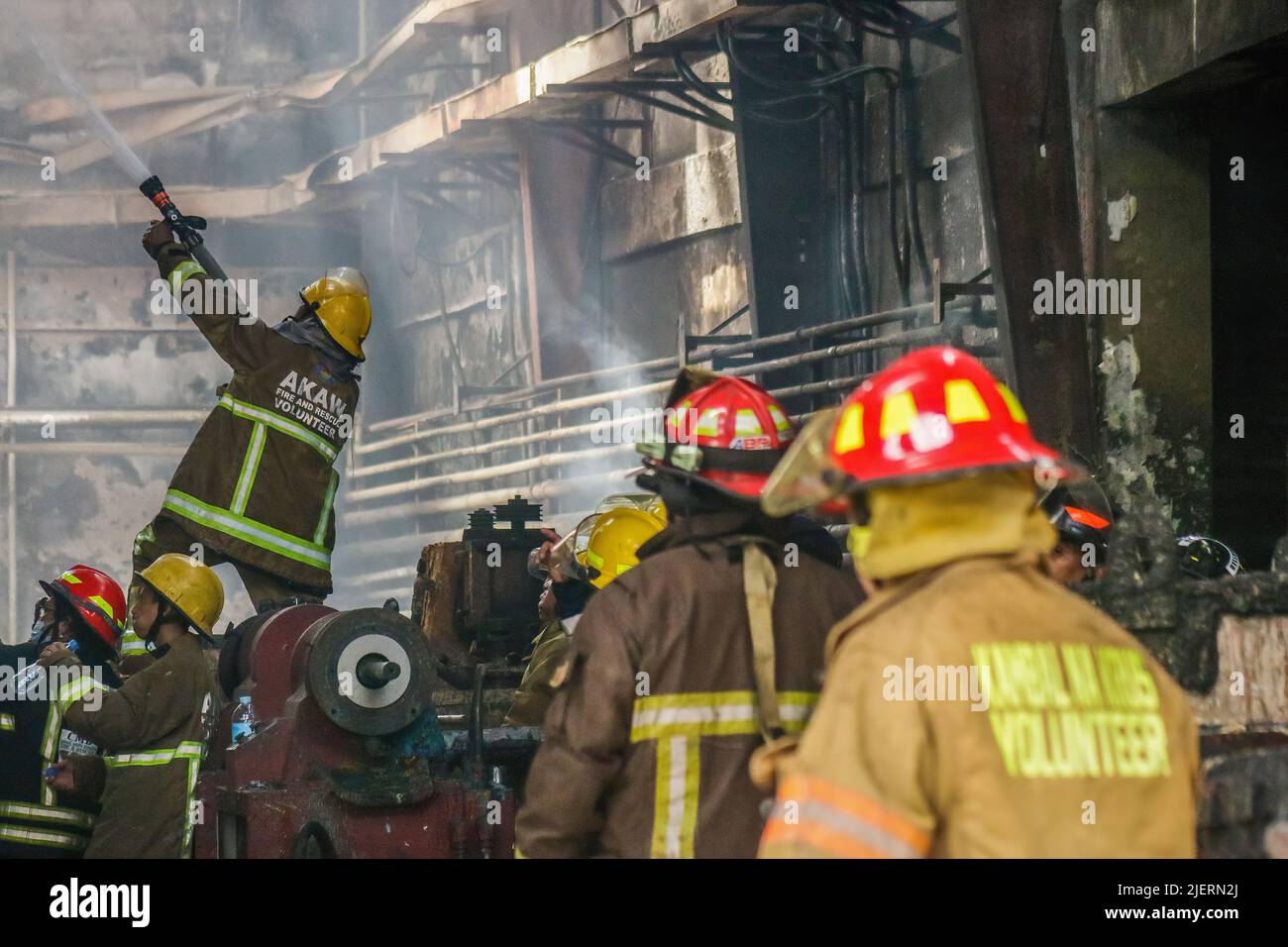 Fire volunteers are seen working inside the fire scene in Dela Paz. A ...