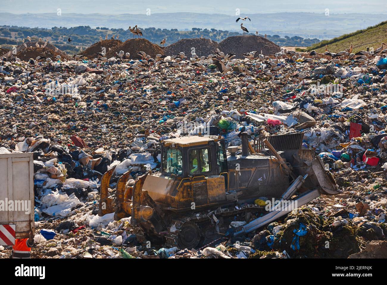 Heavy machinery shredding garbage in an open air landfill. Waste Stock ...