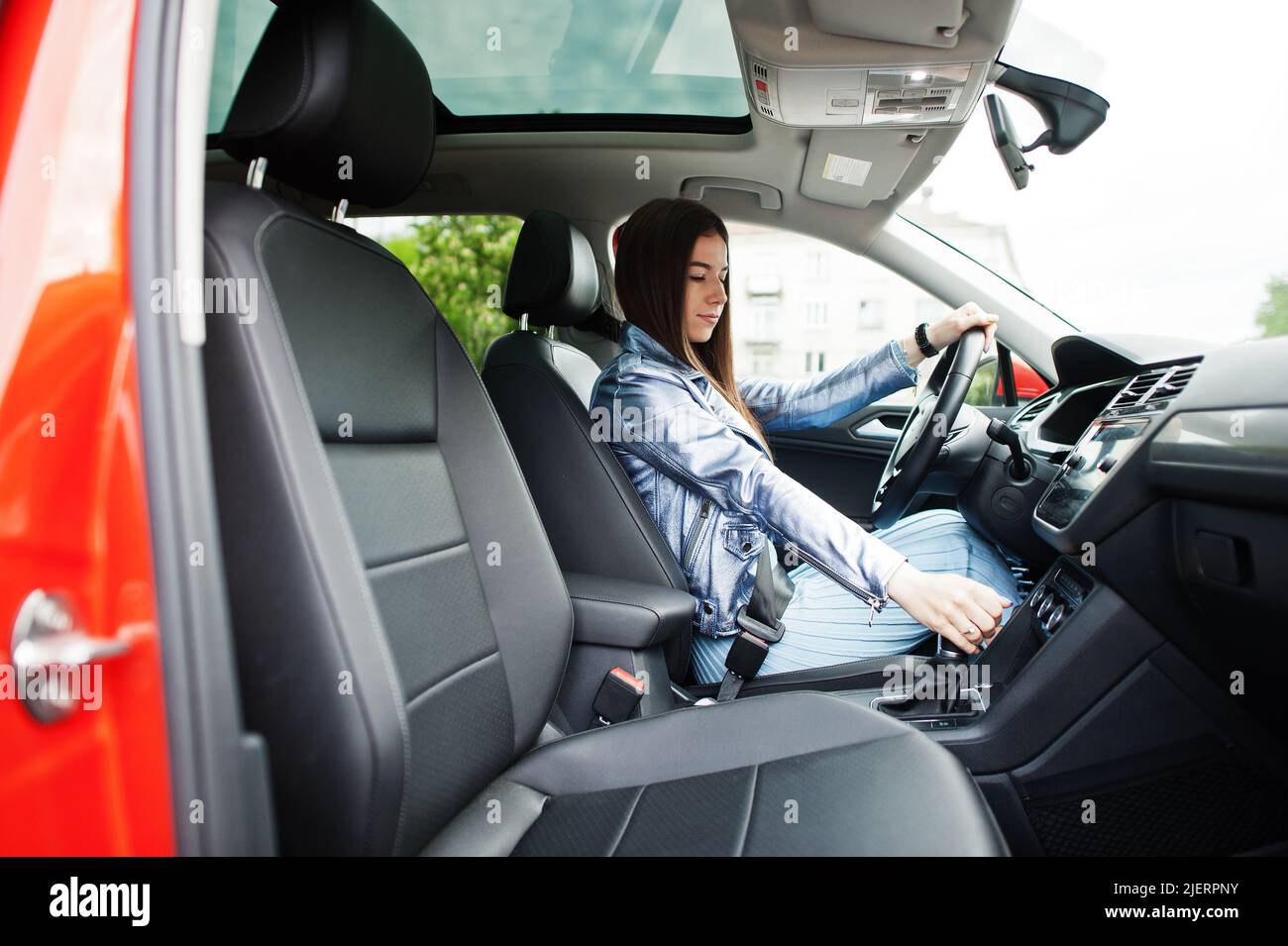 Gorgeous woman sitting inside car with open door Stock Photo - Alamy