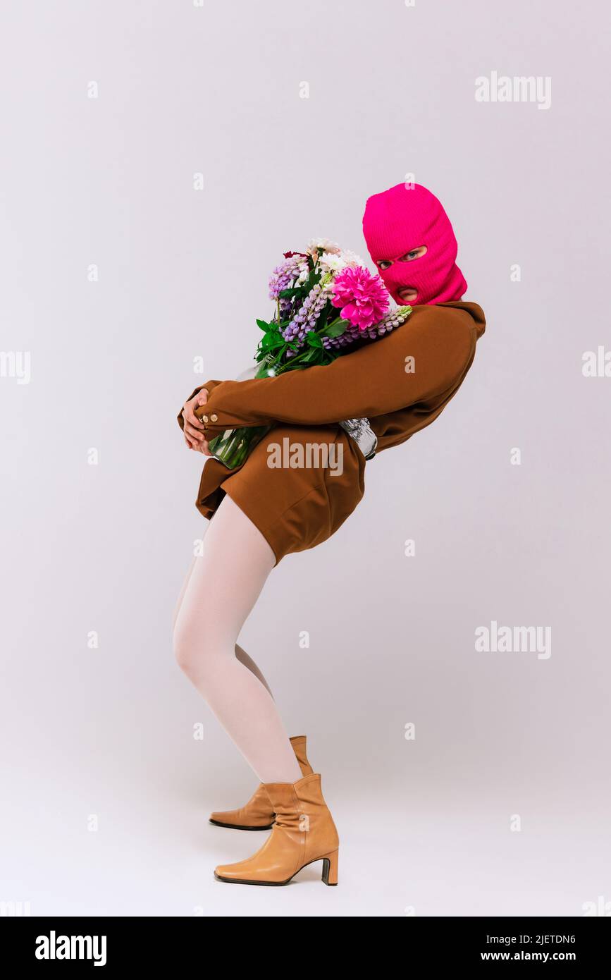 Portrait of stylish girl in oversized brown jacket, white tights, boots ...