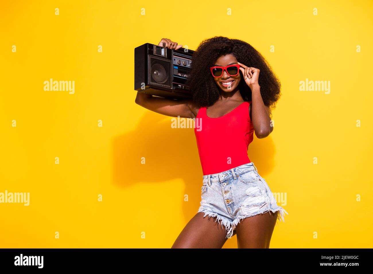 Portrait of attractive cheerful funky girl carrying boombox having fun ...