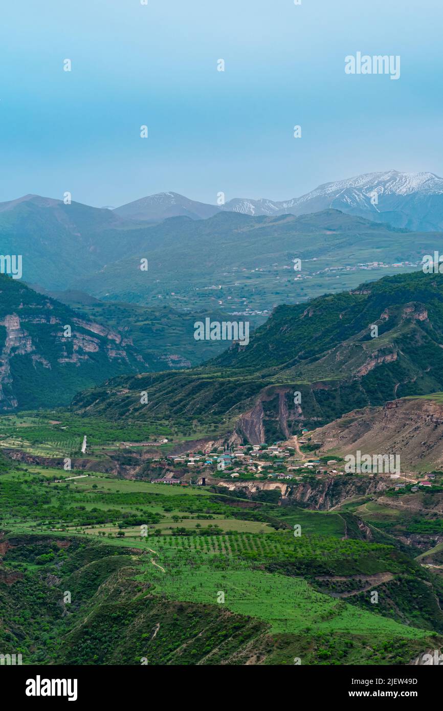 foggy alpine valley with villages and fields between mountain peaks in ...