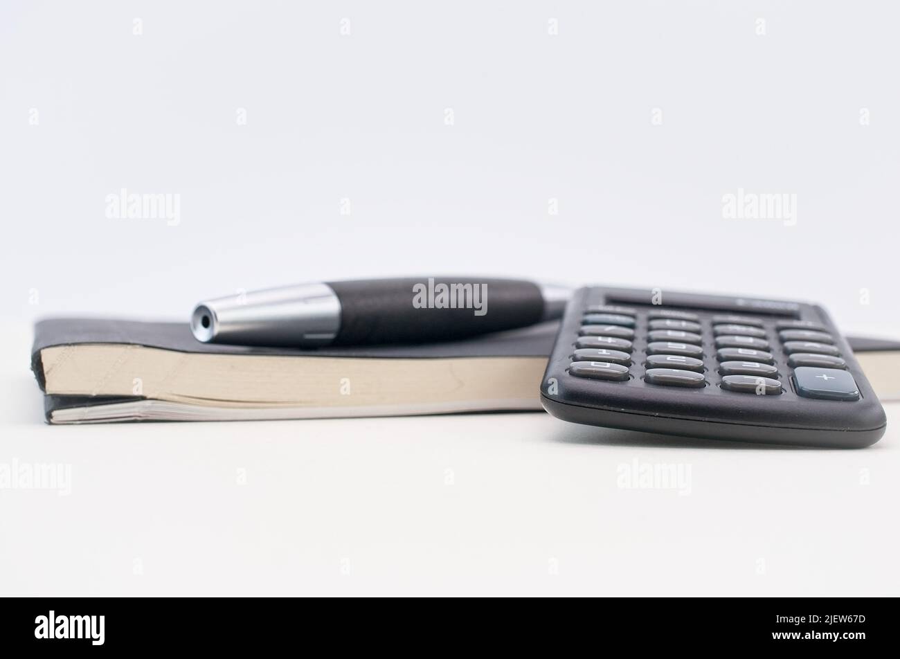 pocket calculator with paper notepad and pencil on a bright white desk ...