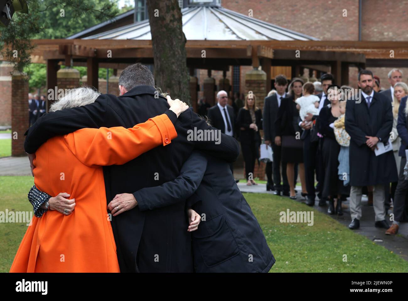 Mourners hug after leaving the funeral of long-time owner of the Irish ...