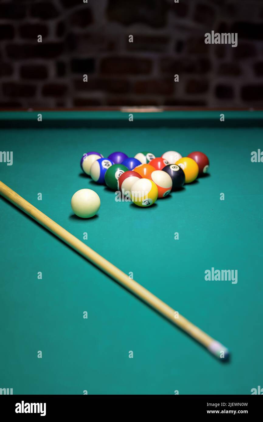 Colorful billiard balls, cue ball and cues on a green table. billiards ...
