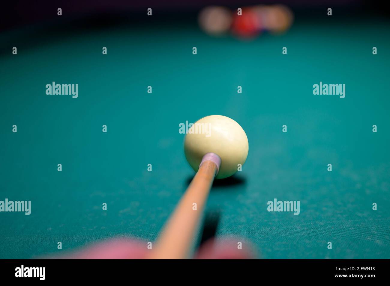 billiard player's hand with whom and ball on the billiard table ...