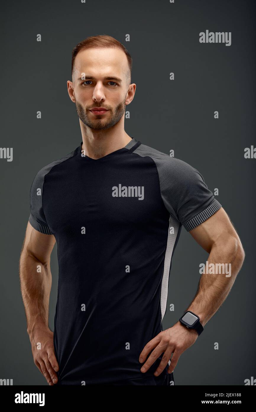 Half length portrait of young sporty guy in t-shirt and shorts standing ...