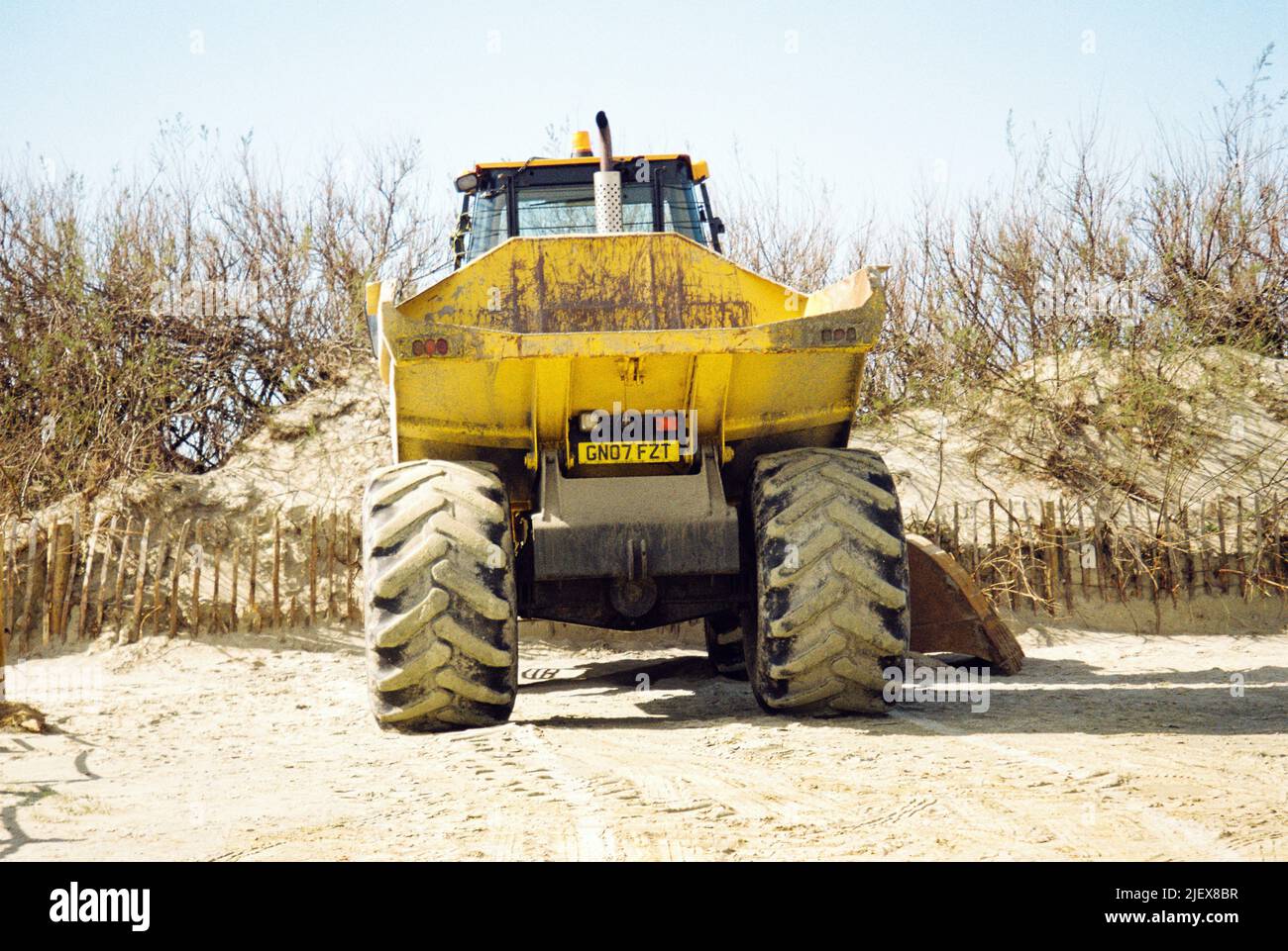 large yellow dumper truck at West Wittering beach, West Sussex, England ...